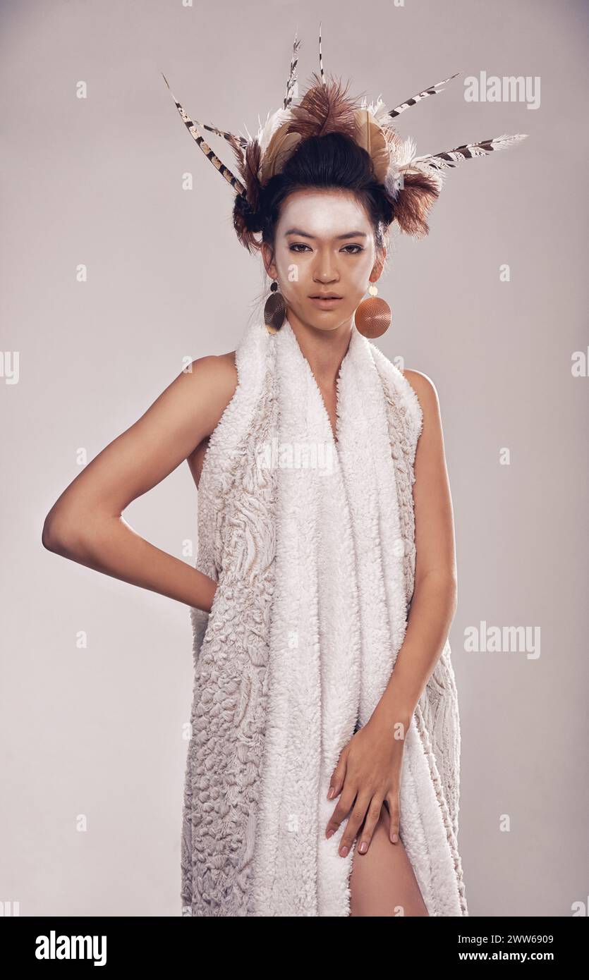 Model, portrait or culture headdress in studio with feathers, fashion ...