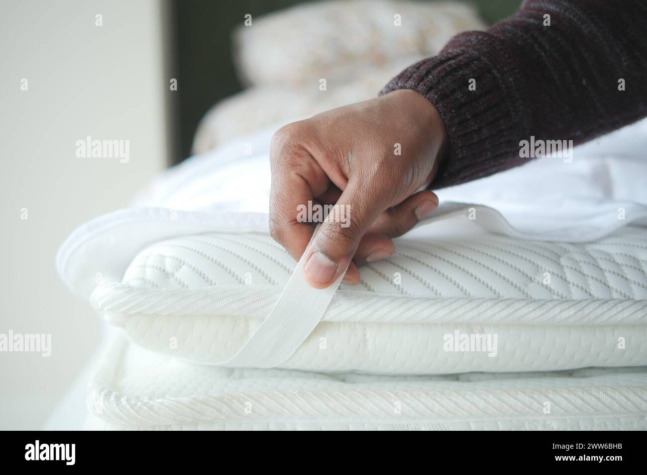 Placing the white sheet on the mattress for added comfort Stock Photo ...