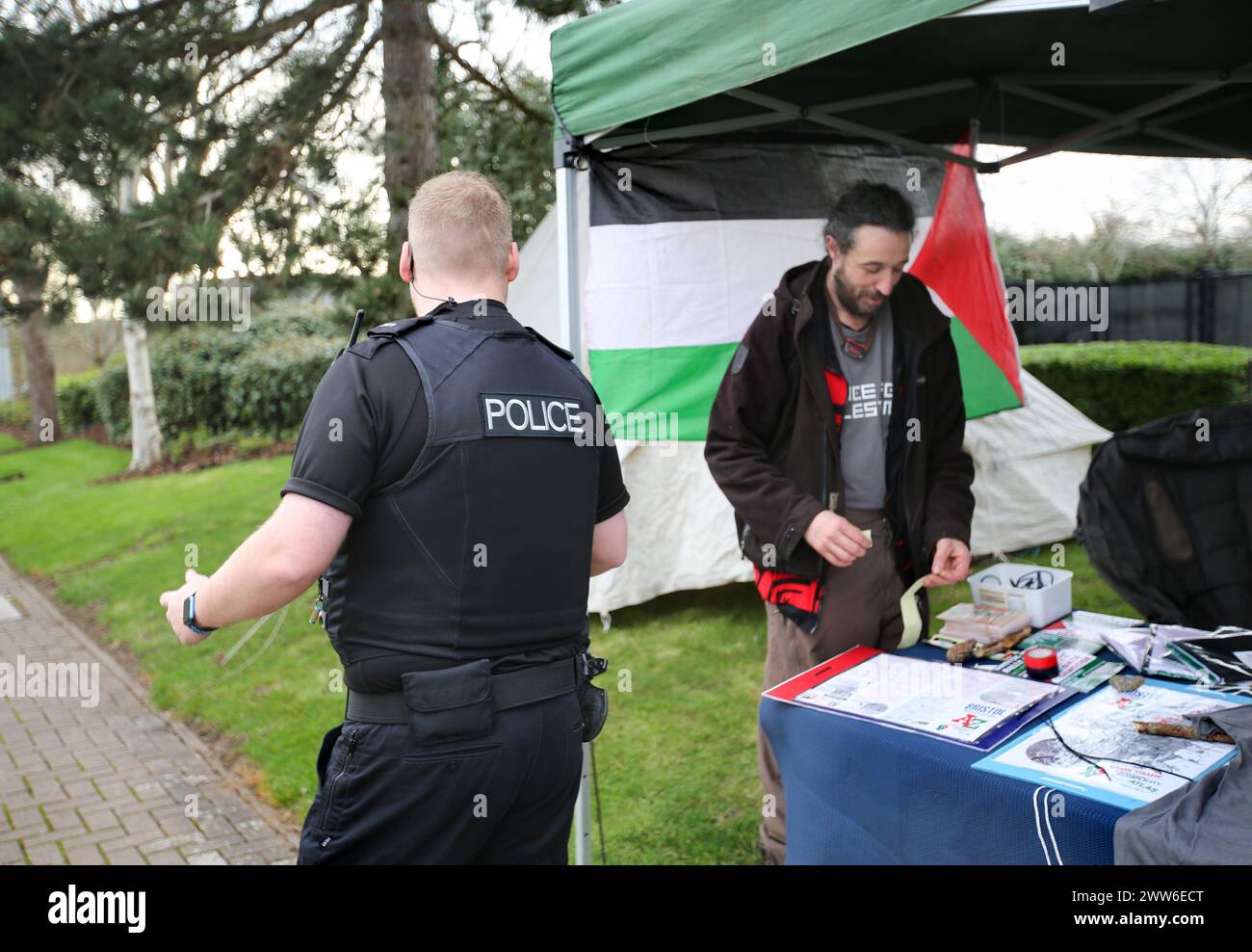 A police officer speaks to a protester as he sets up a camp on the ...