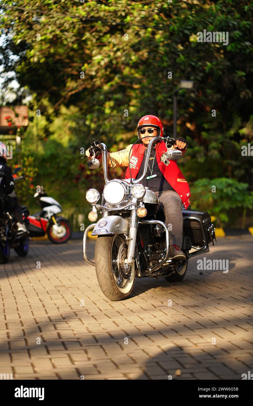 a man riding a mini motorbike with half face helmet Stock Photo - Alamy