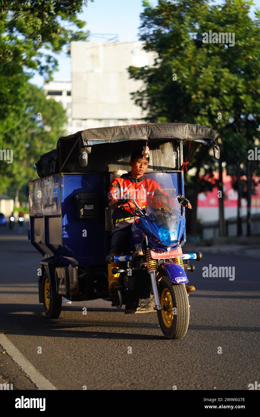 a man riding a mini motorbike with half face helmet Stock Photo - Alamy