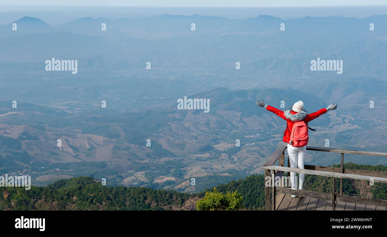 Asian female tourists happily spread their hands at a mountain viewing ...