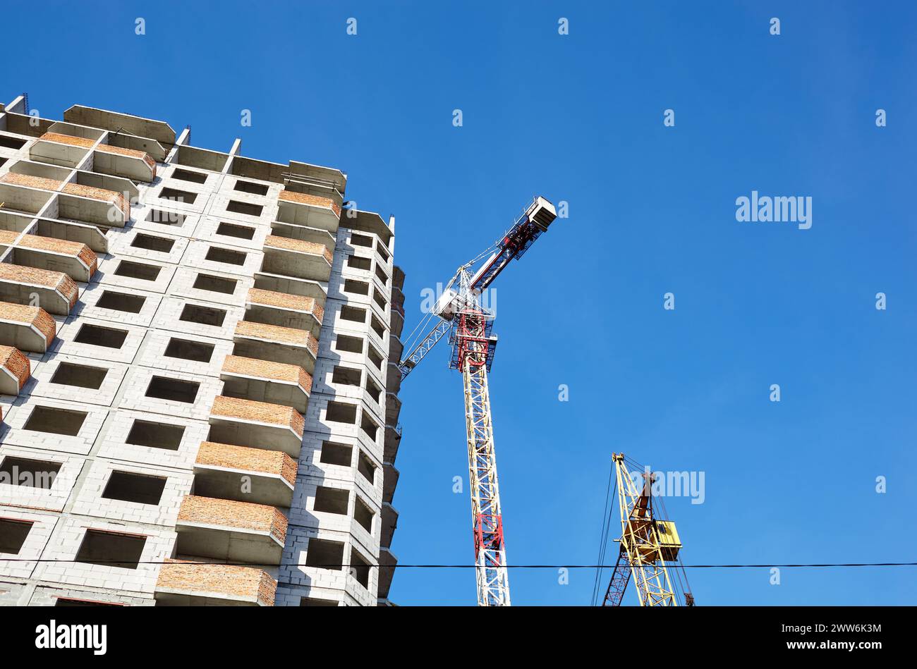 Tower cranes building a house. Concrete building under construction ...