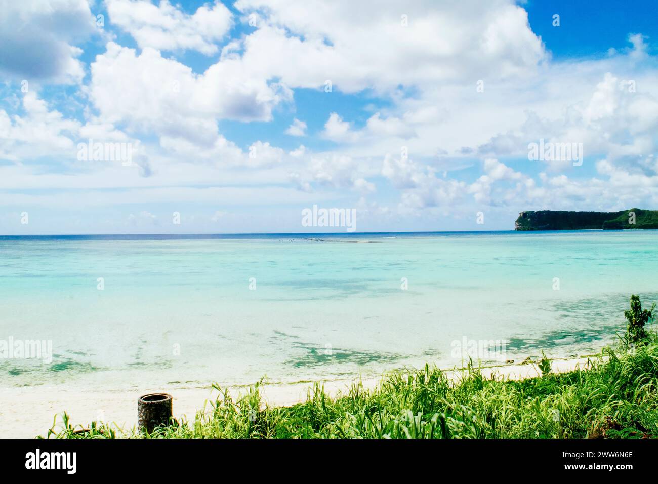 A scenic view of fluffy white clouds over sandy Tumon Beach, Guam, USA ...