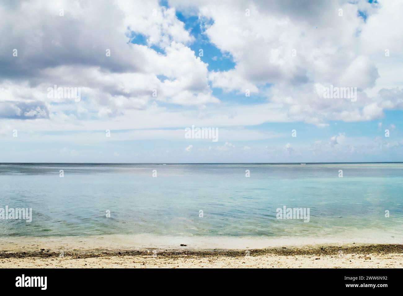 A scenic view of fluffy white clouds over sandy Tumon Beach, Guam, USA ...