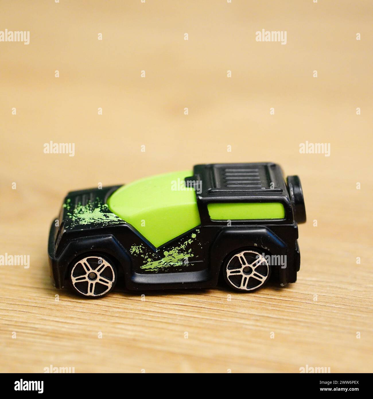 A green and black toy car on a wooden surface Stock Photo - Alamy
