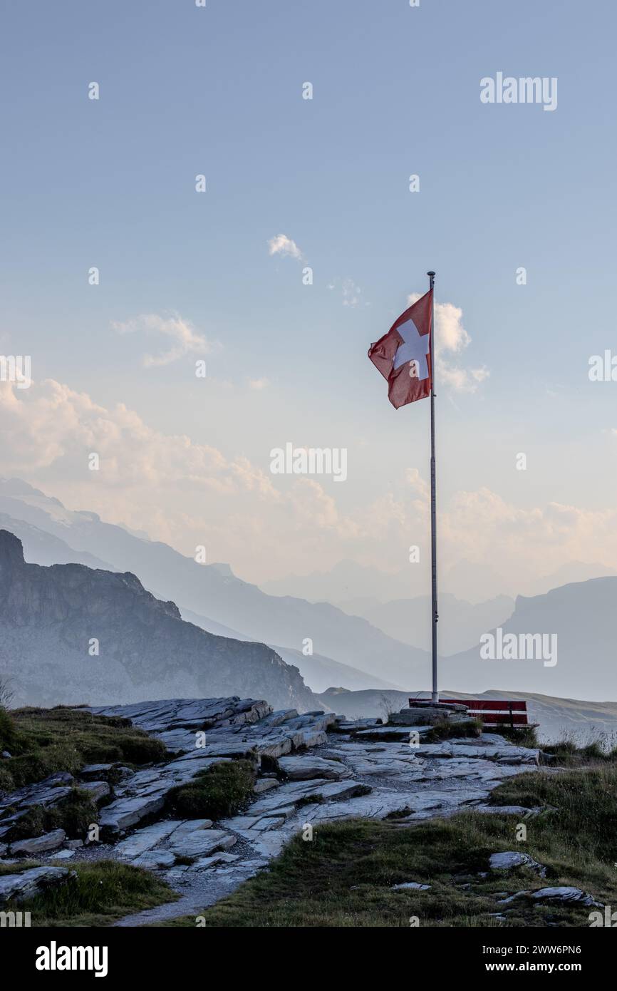 Swiss flag waving with Mountains background Stock Photo - Alamy