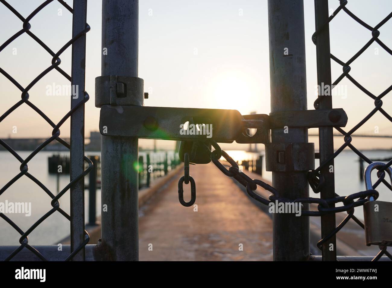 The sun setting behind lock on dock gate Stock Photo - Alamy