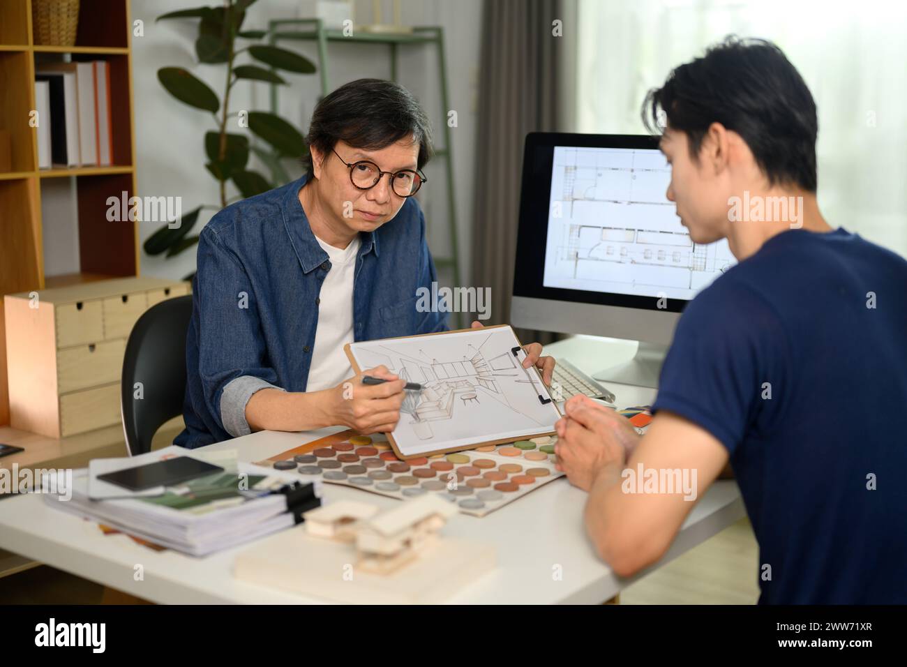 Interior designer man discussing building plan design project with his ...