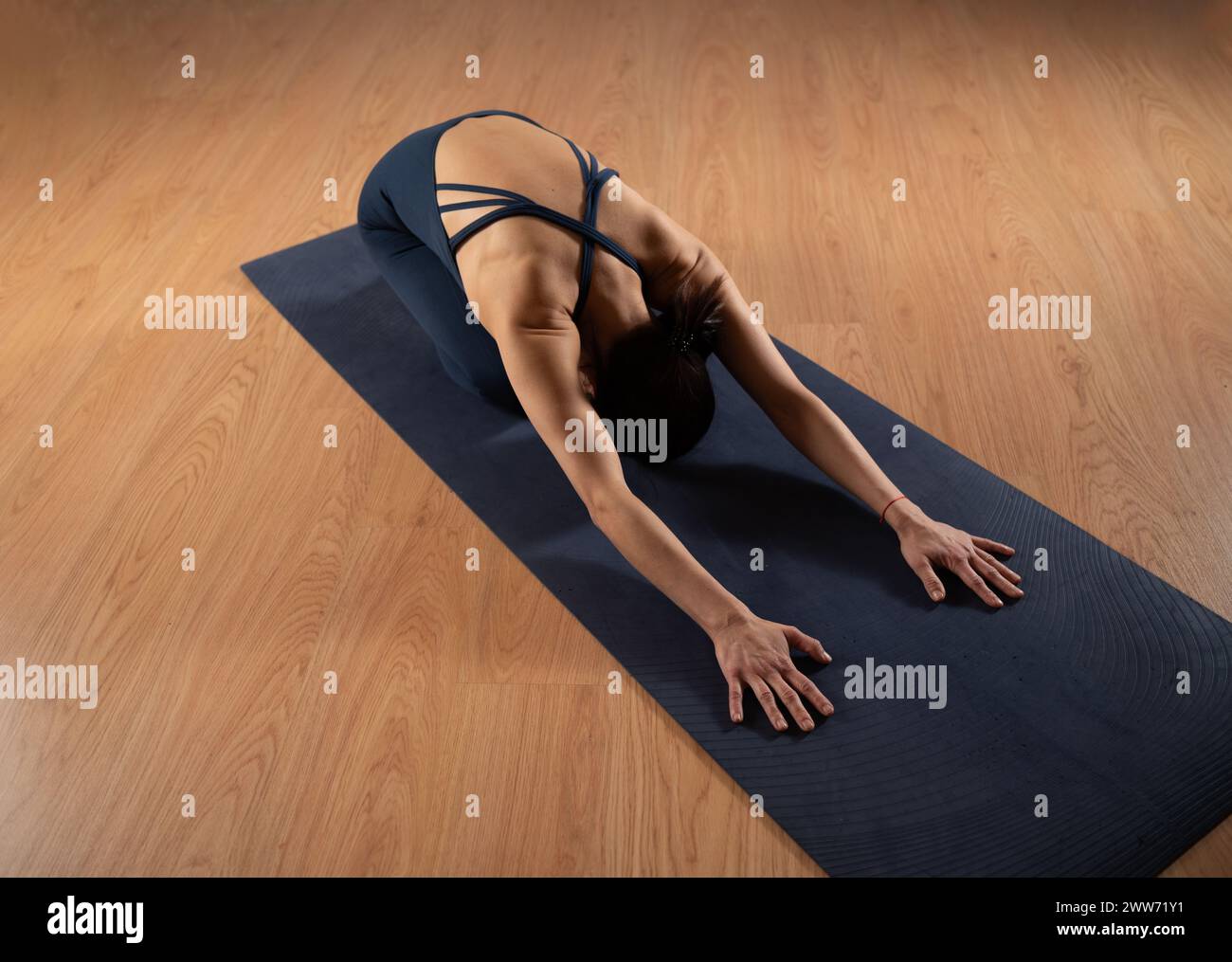 Woman in Balasana position with arms outstretched. Yoga concept Stock ...