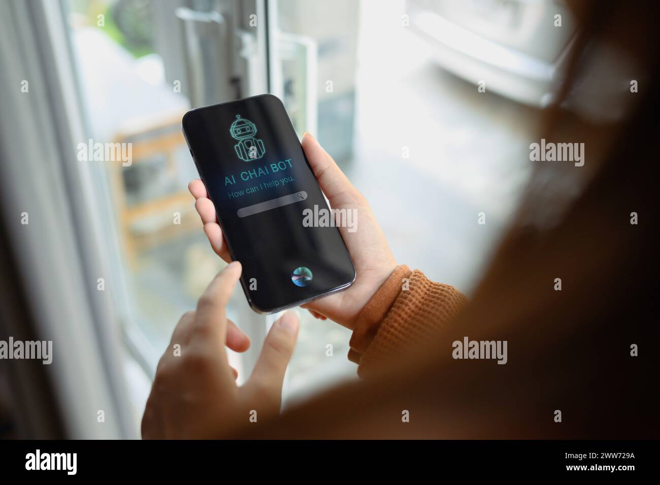 Over shoulder view of woman using AI Chat bot in mobile application and ...