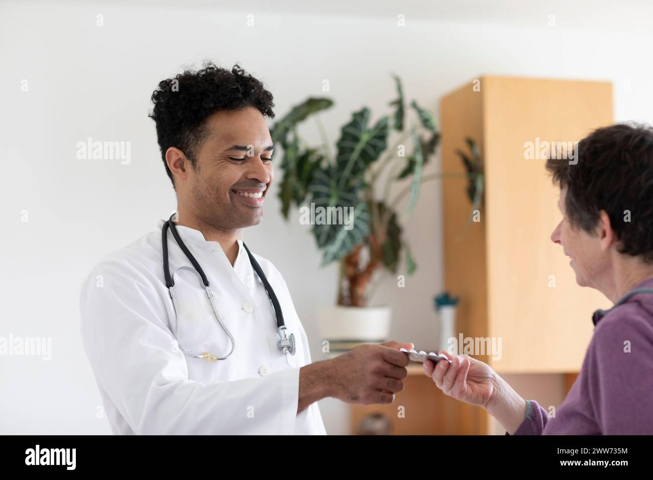 doctor, male, mixed race in a practice with a patient Stock Photo - Alamy