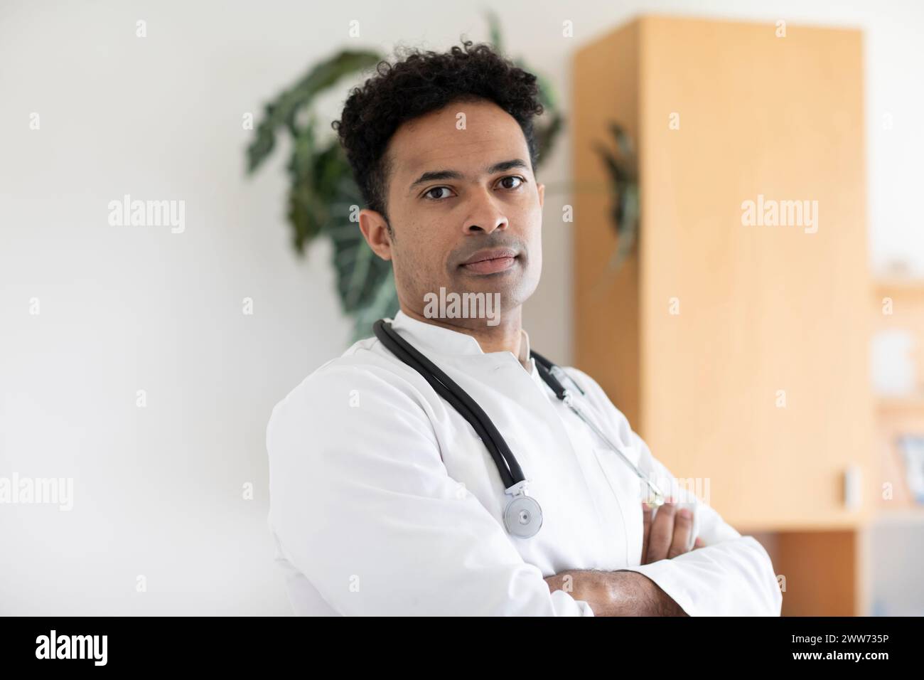 doctor, male, mixed race in a practice with shranked arms Stock Photo ...