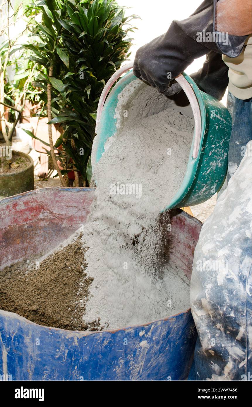Caucasian bricklayer pouring cement on sand in container Stock Photo ...