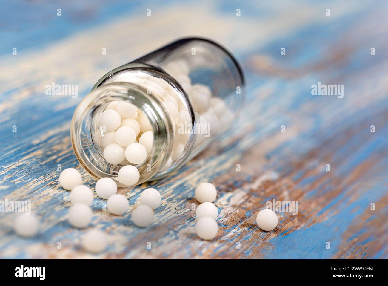 Homeopathy : close-up of homeopathic granules spilling out among small ...
