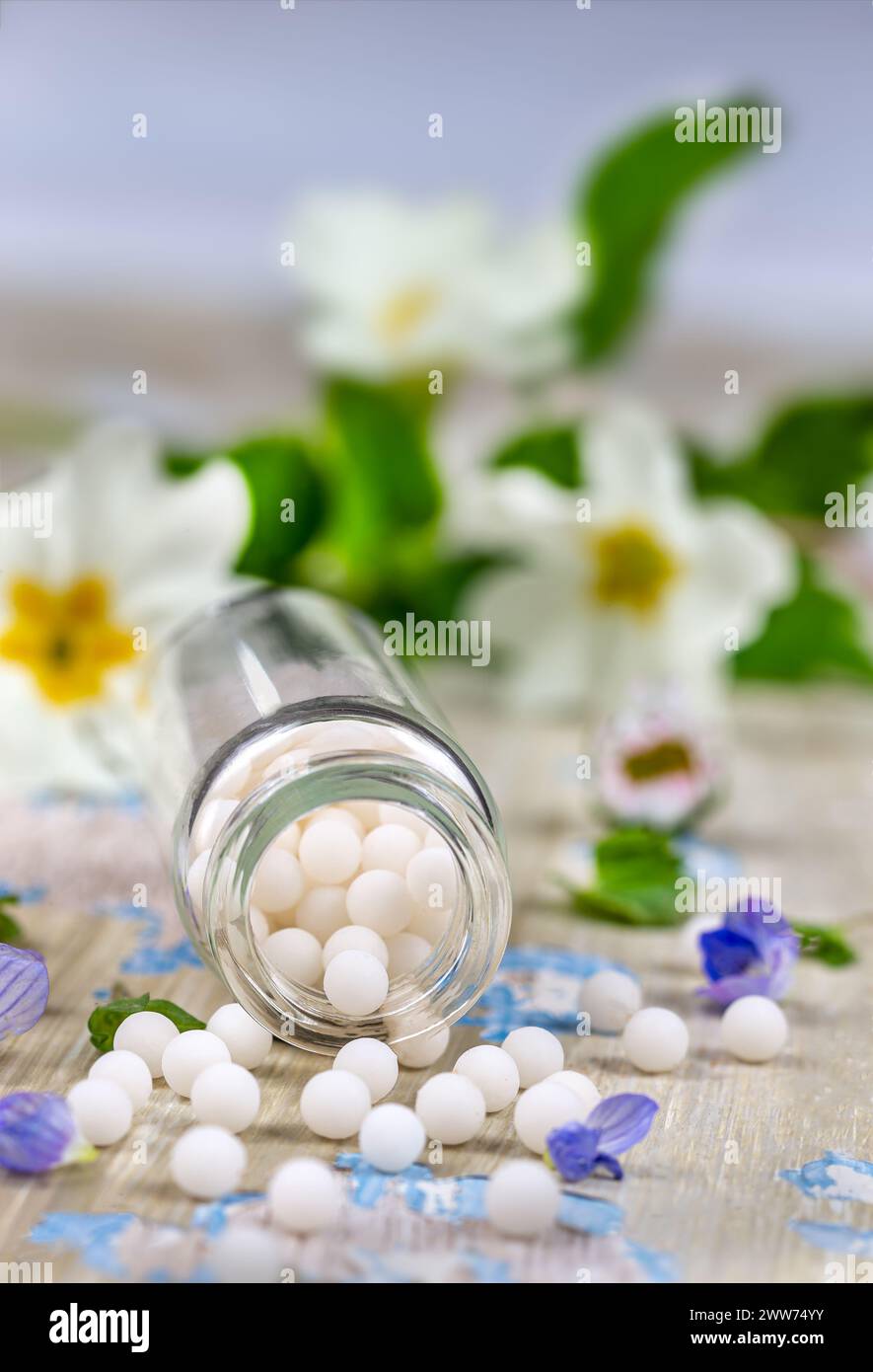 Homeopathy : close-up of homeopathic granules spilling out among small ...