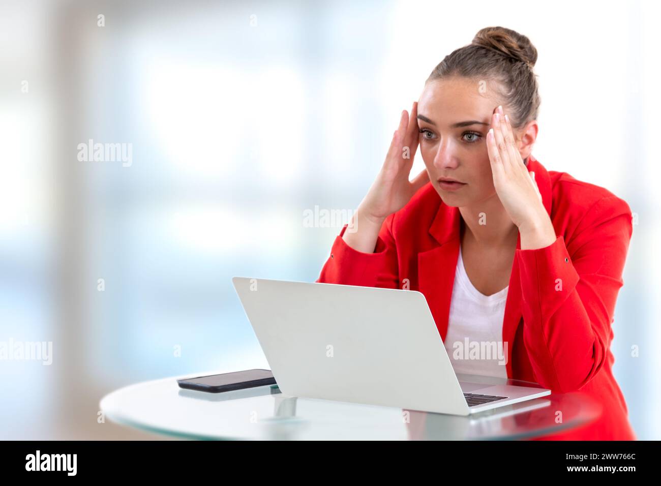 Woman facing her computer clutching her head with her fingers Stock ...