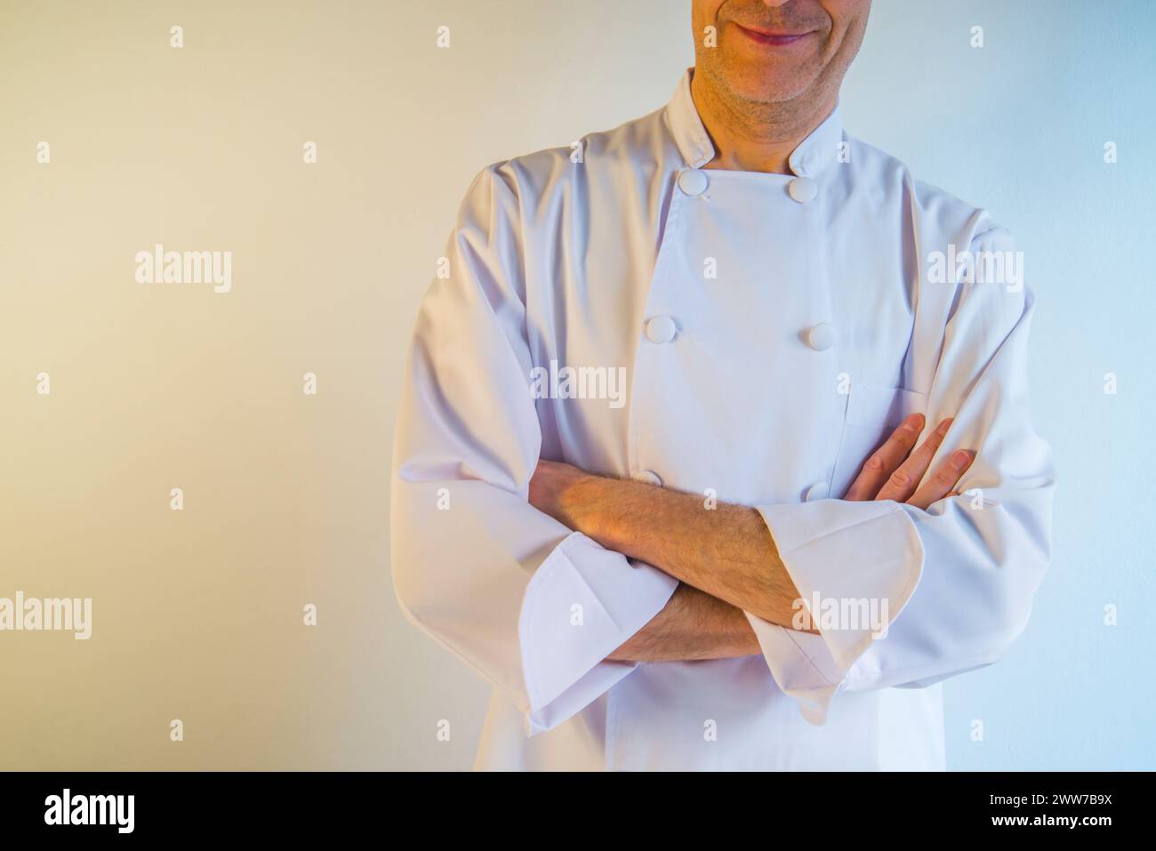 Cook smiling, crossing arms Stock Photo - Alamy