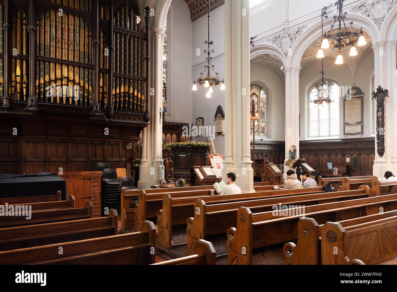 The serene interior of a church, featuring a grand pipe organ, wooden ...