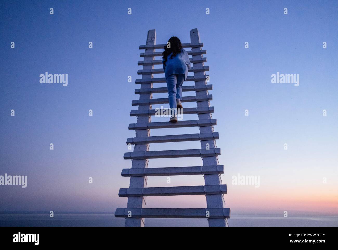 An attractive Asian woman is laughing and sitting at the top of a ...