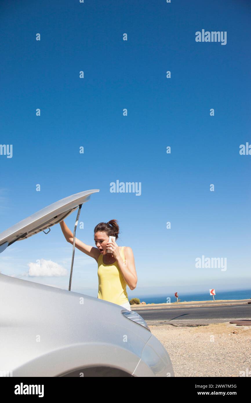 Woman looking under hood car hi-res stock photography and images - Alamy