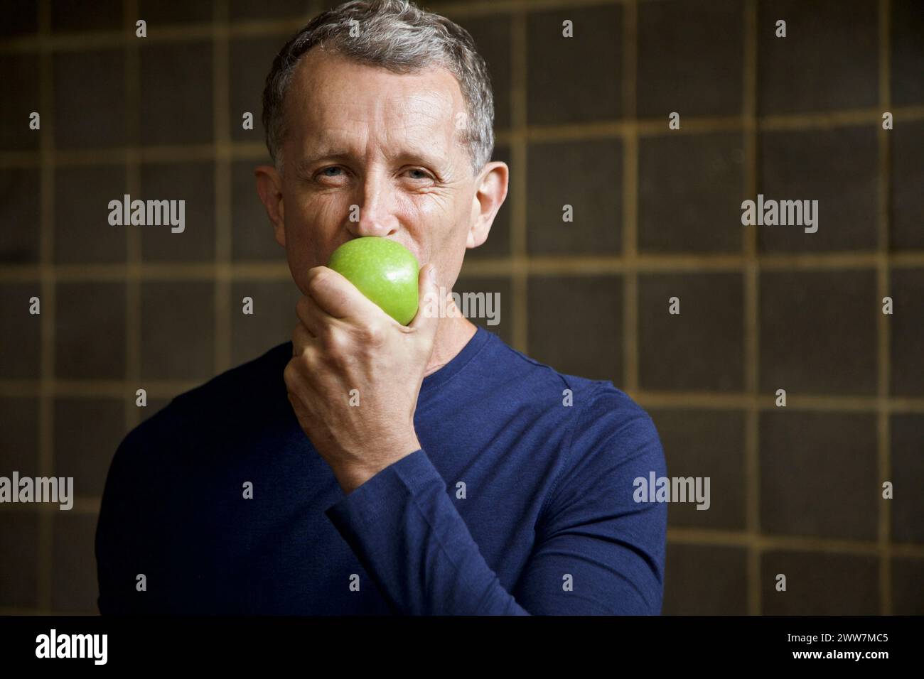 Mature Man Biting an Apple Stock Photo - Alamy