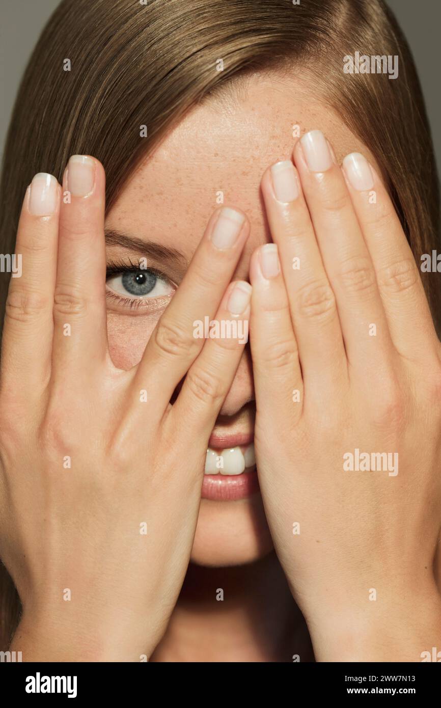 Woman with Hands over Eyes Smiling Stock Photo - Alamy