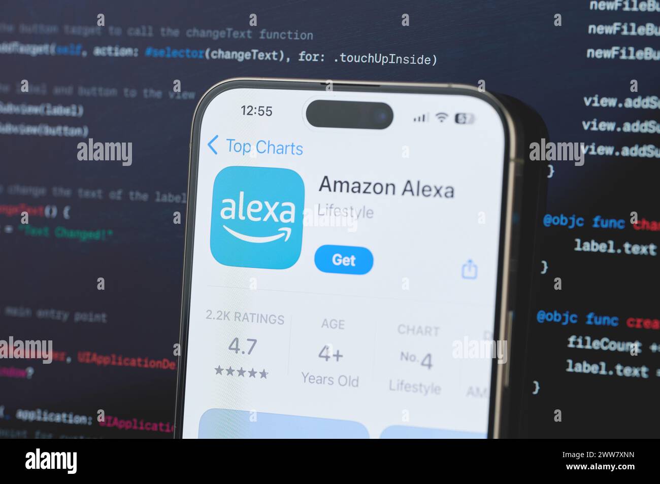 New York, USA - February 23, 2024: Amazon Alexa on iphone screen in blurred code programming ...