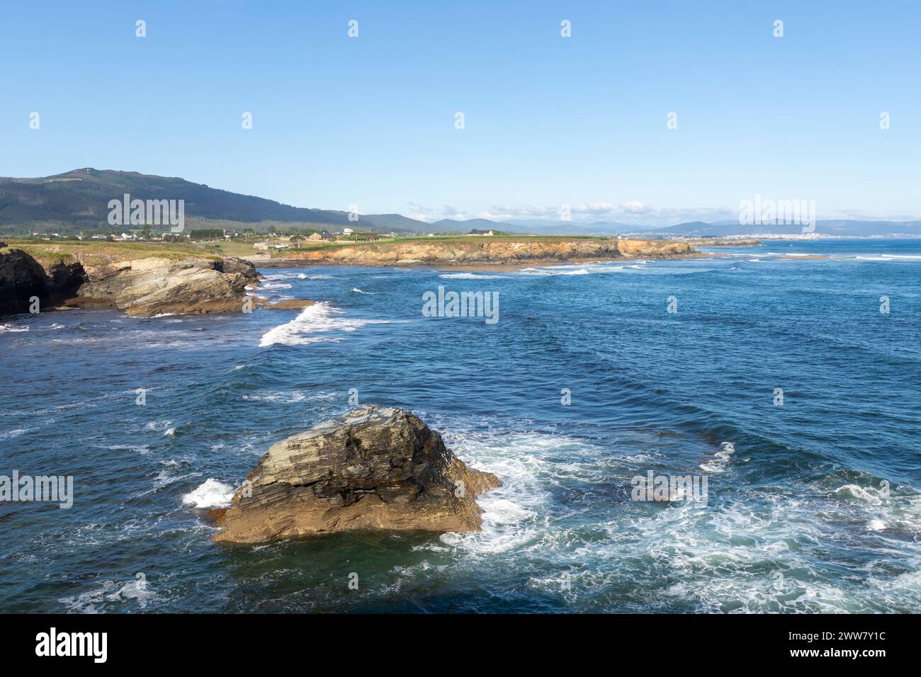 scenic coastline with rocky formations, blue waters, and distant ...