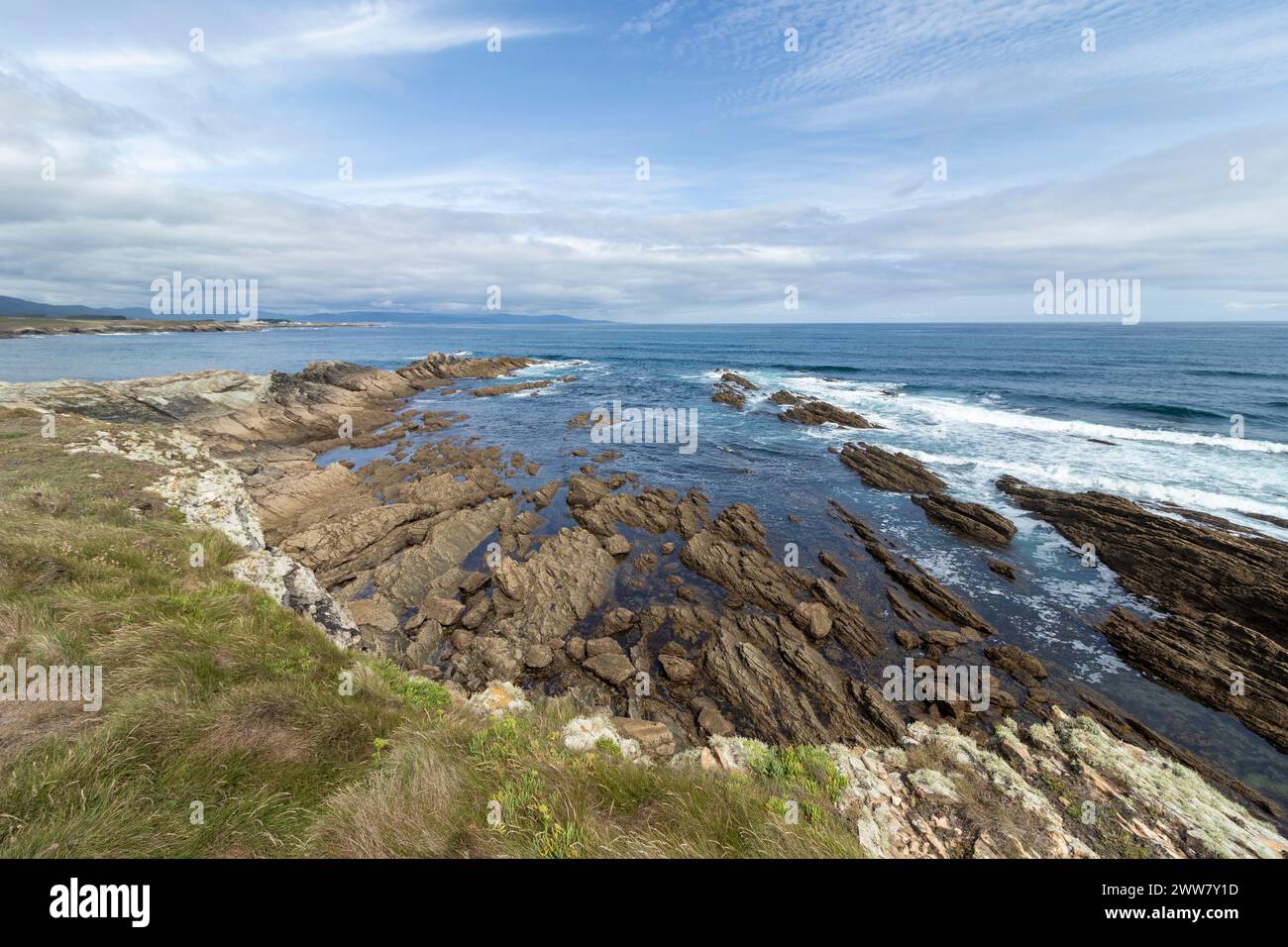 scenic coastline with rocky formations, blue waters, and distant ...