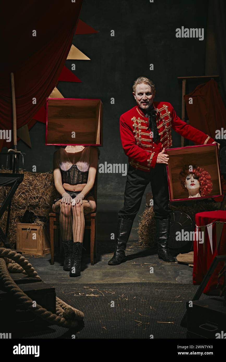 Tricks. Magician in red coat showing tricks with headless female ...