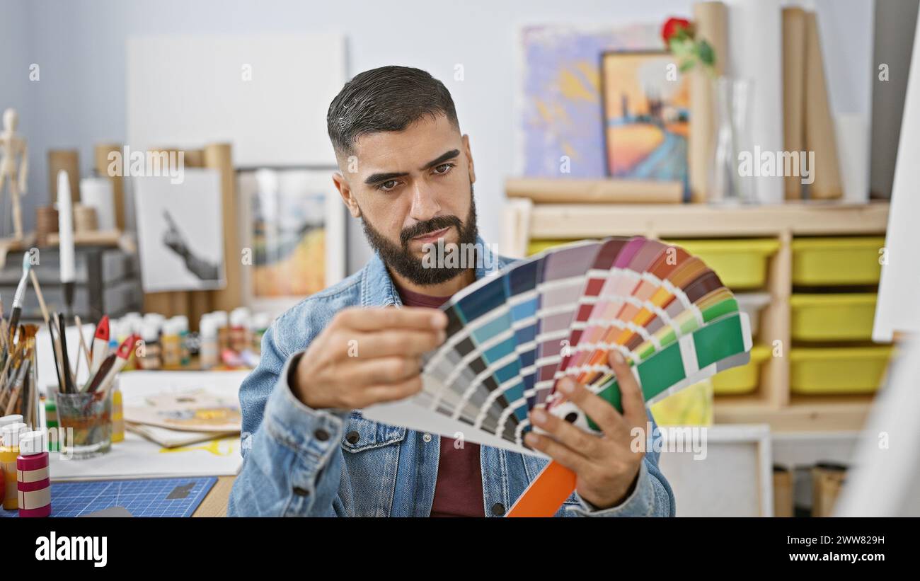 A focused young man carefully selecting colors from a swatch in a ...