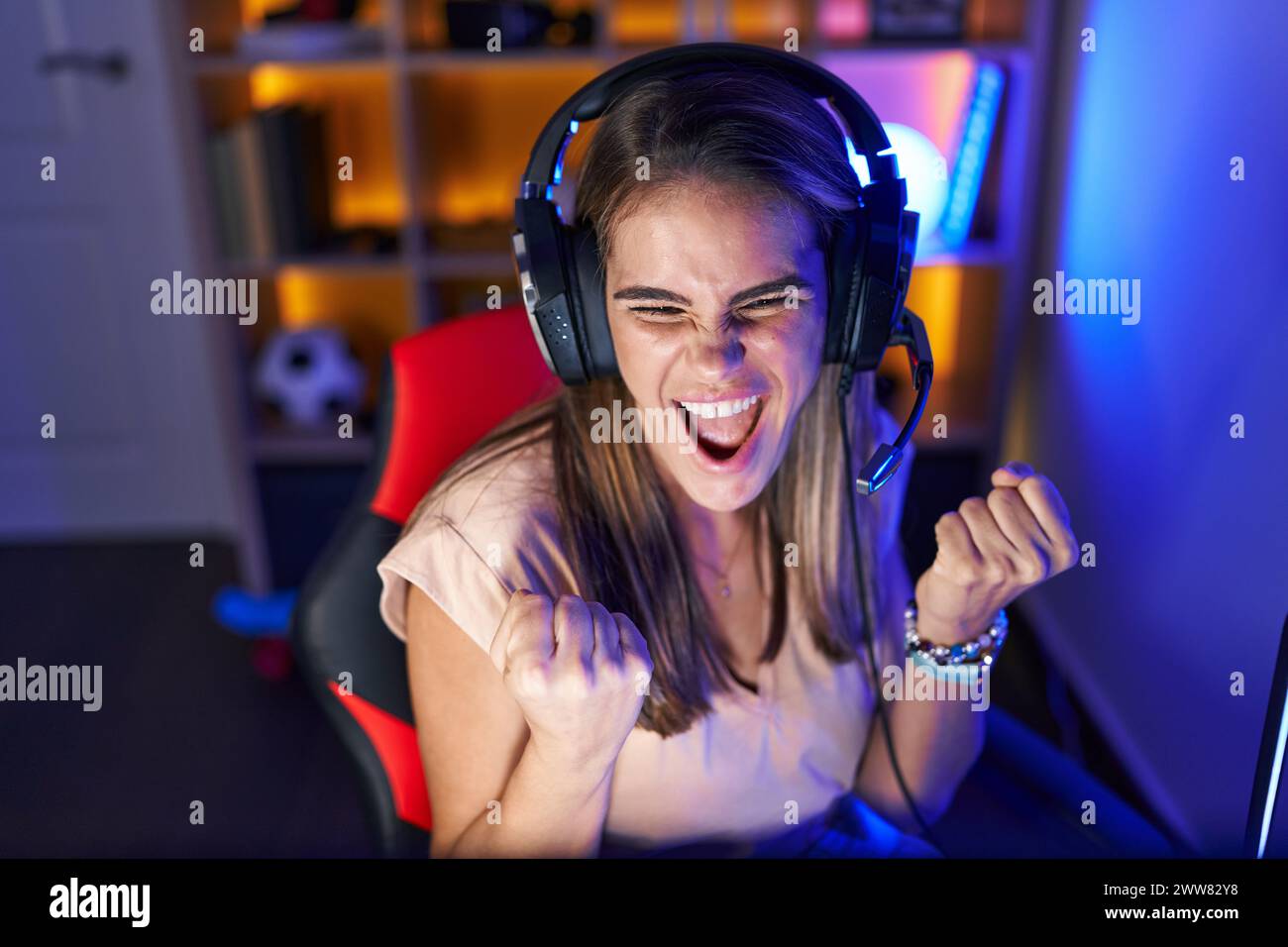 Young beautiful hispanic woman streamer playing video game with winner ...