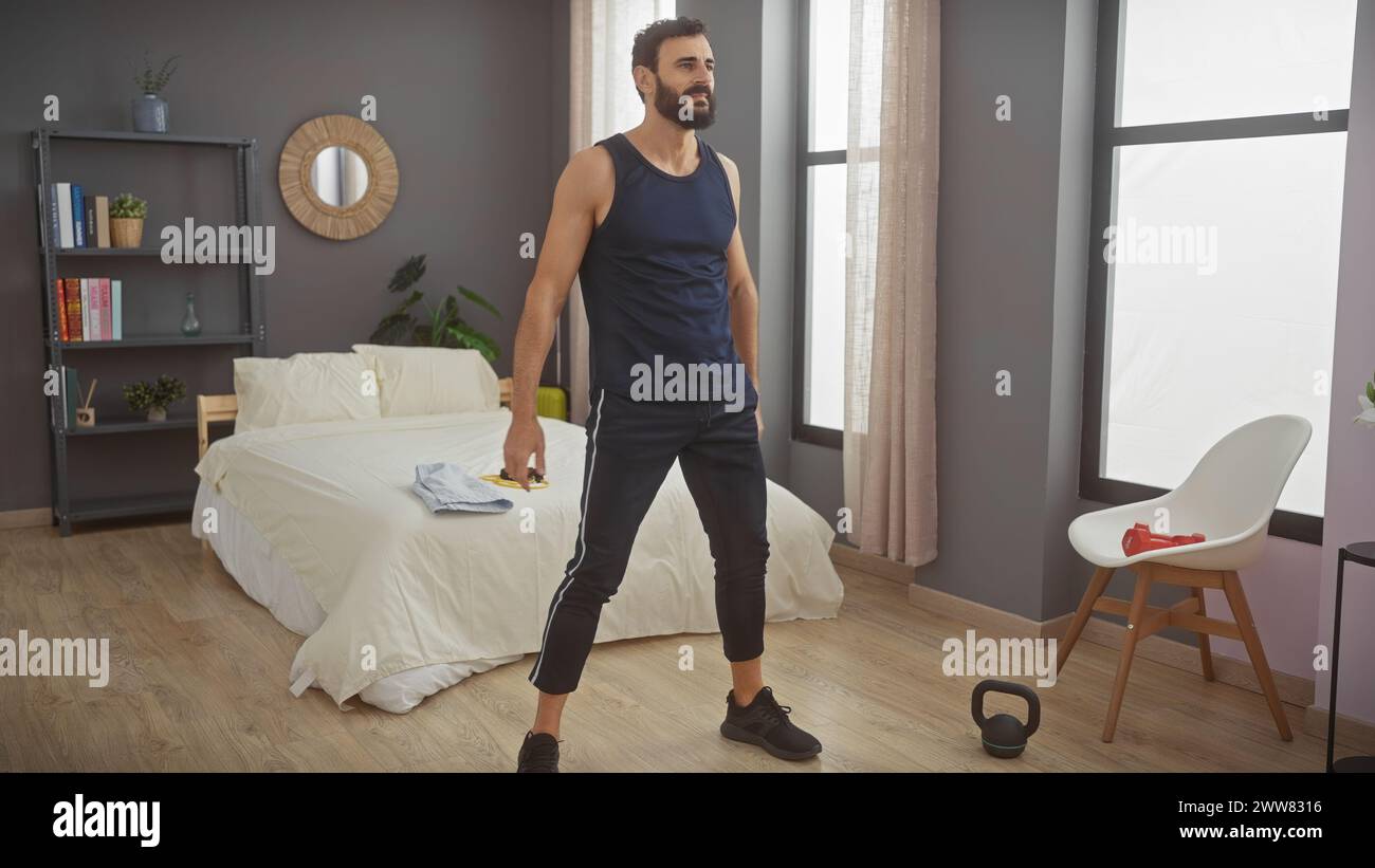 Bearded man in bedroom stands confidently, displaying a healthy ...