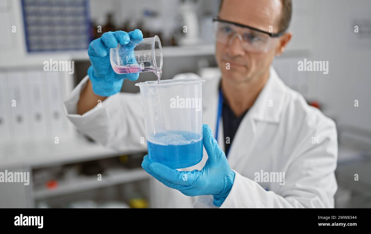 Middle age man scientist measuring liquid at laboratory Stock Photo - Alamy