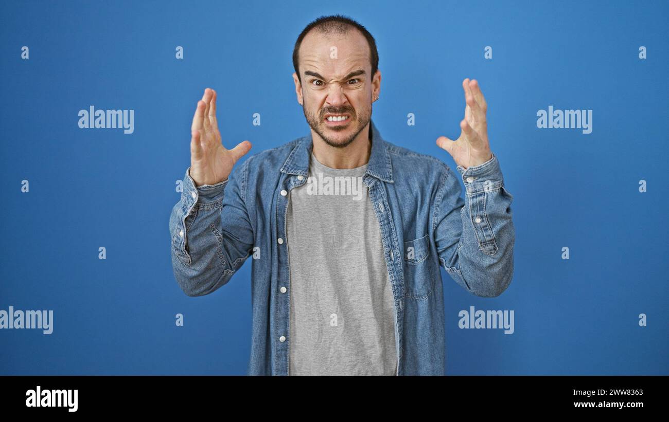 Bald hispanic man with beard in denim shirt gesturing frustration ...
