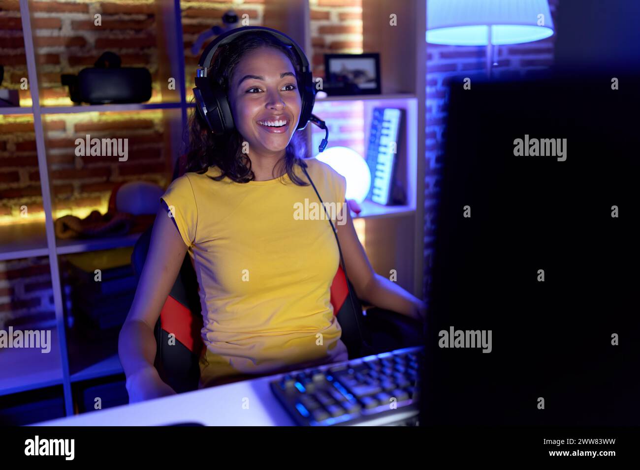 Young african american woman streamer playing video game using computer ...