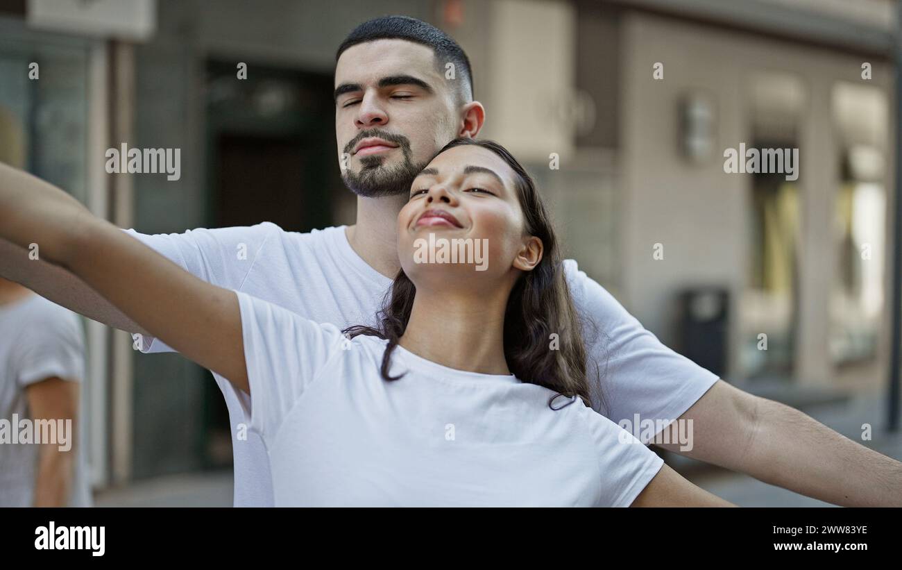 Beautiful couple stands together, arms open, confidently breathing in ...