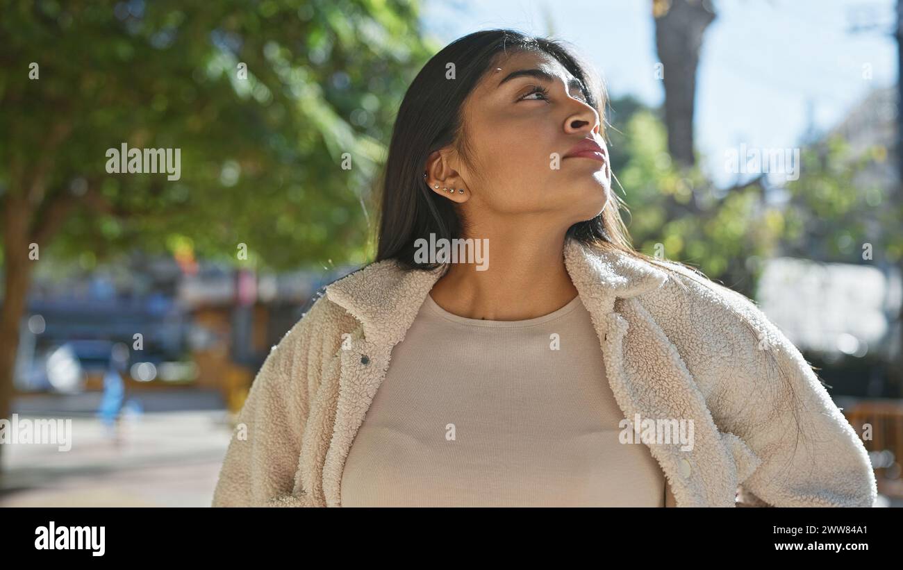 Beautiful south asian woman with long hair enjoying sunny day outdoors ...