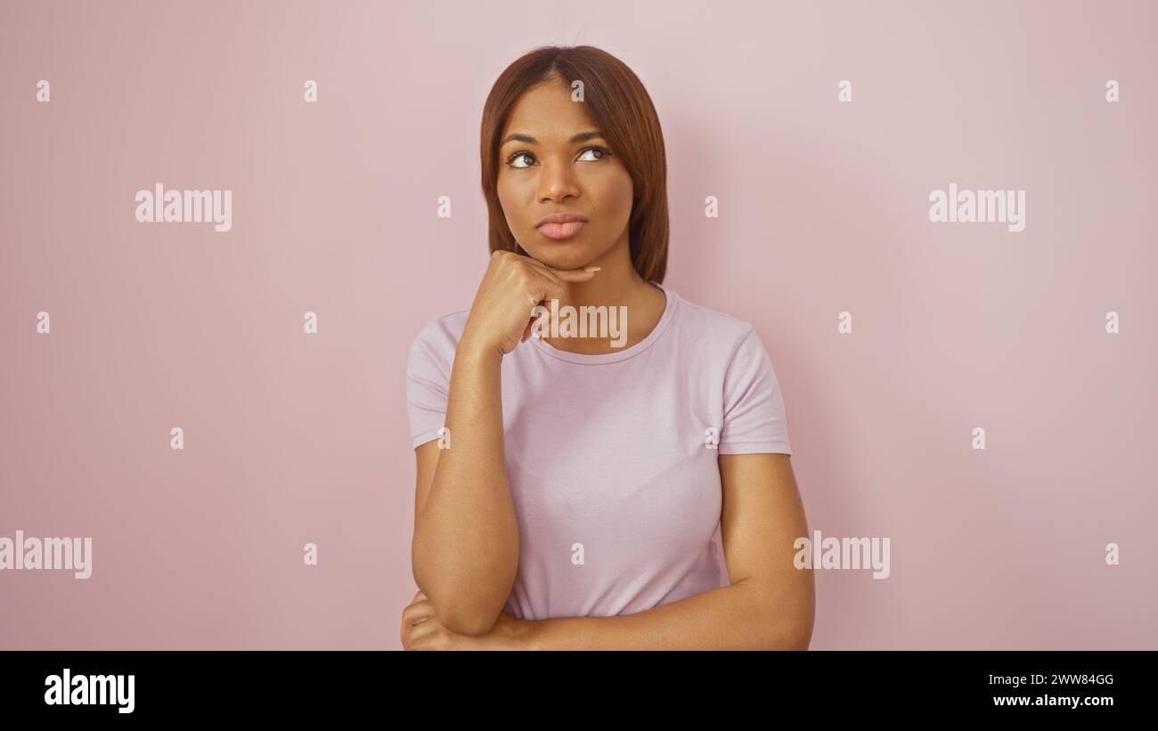 Pensive african american woman isolated on a pink background, with a ...