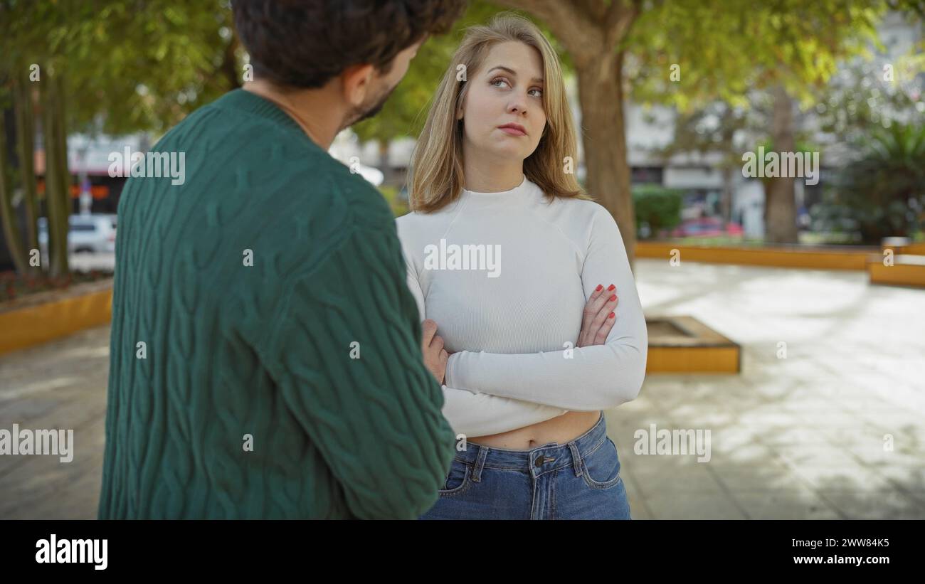 A couple encountering relationship tension in a city park, depicted by ...