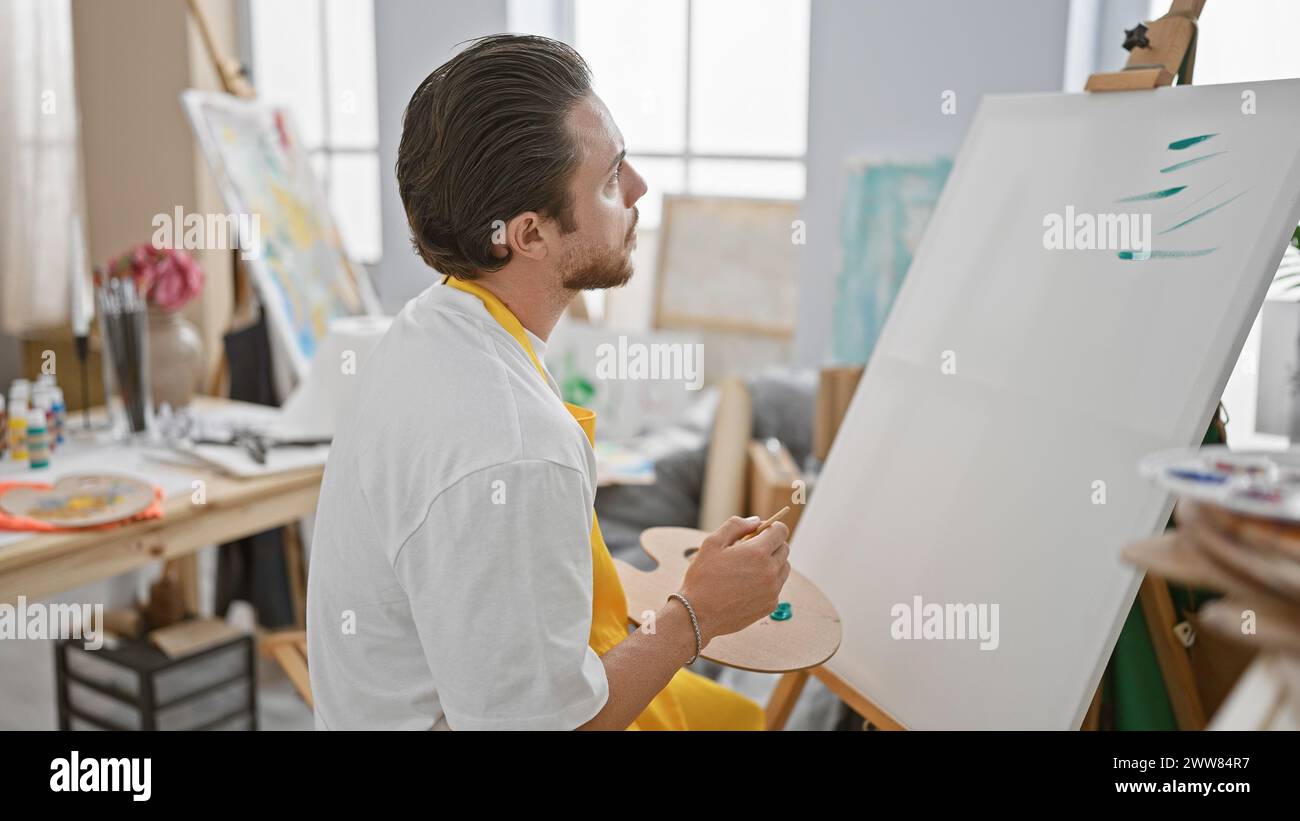 Young hispanic man artist drawing concentrated at art studio Stock ...