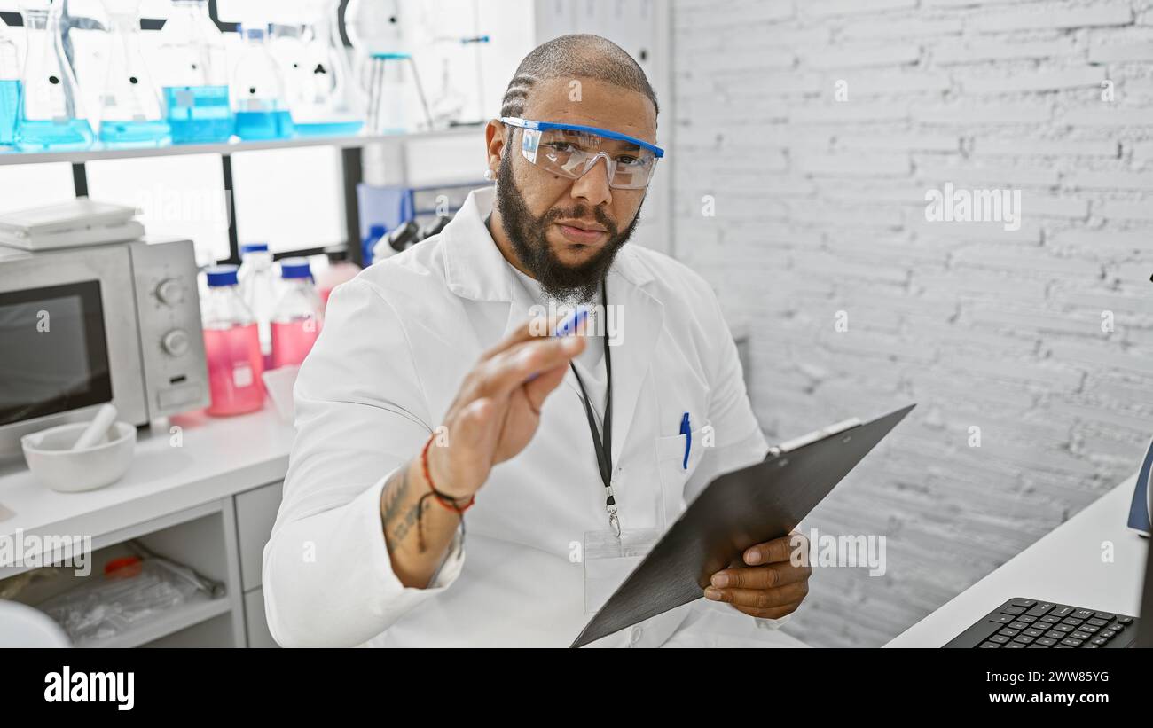 Professional black man in lab coat holding a clipboard in a modern ...