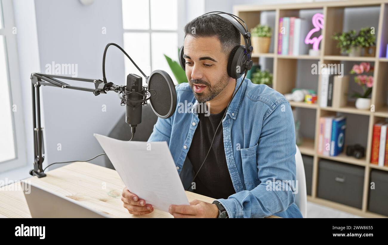 Handsome hispanic man with beard reading script in radio studio Stock ...