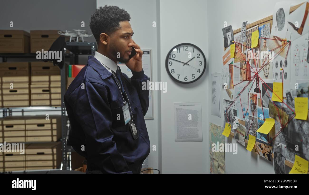 African american detective in office using phone with crime board in ...