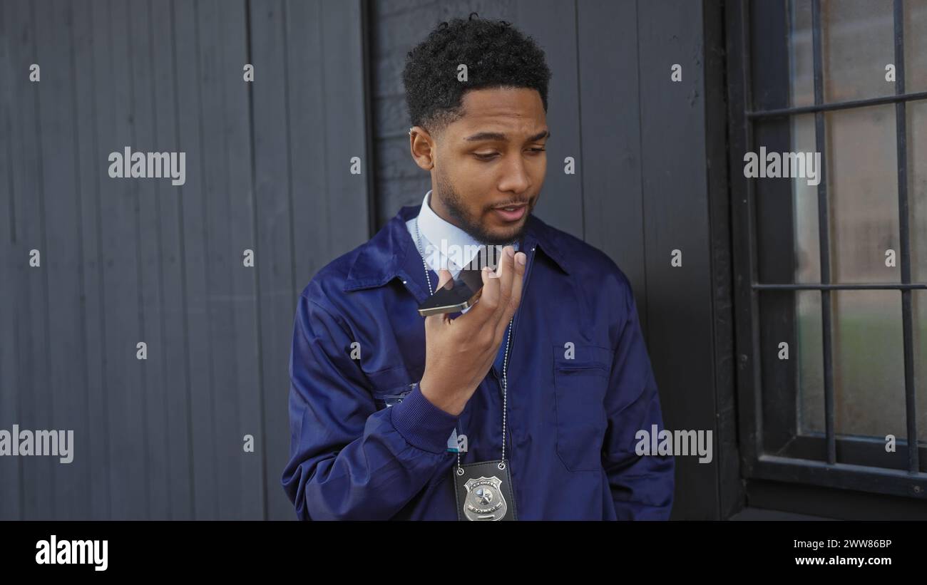 Handsome african-american police officer using smartphone on urban city ...