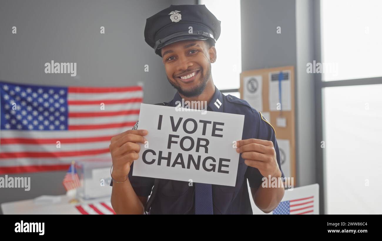 A smiling african american policeman in uniform holding a 'i vote for ...