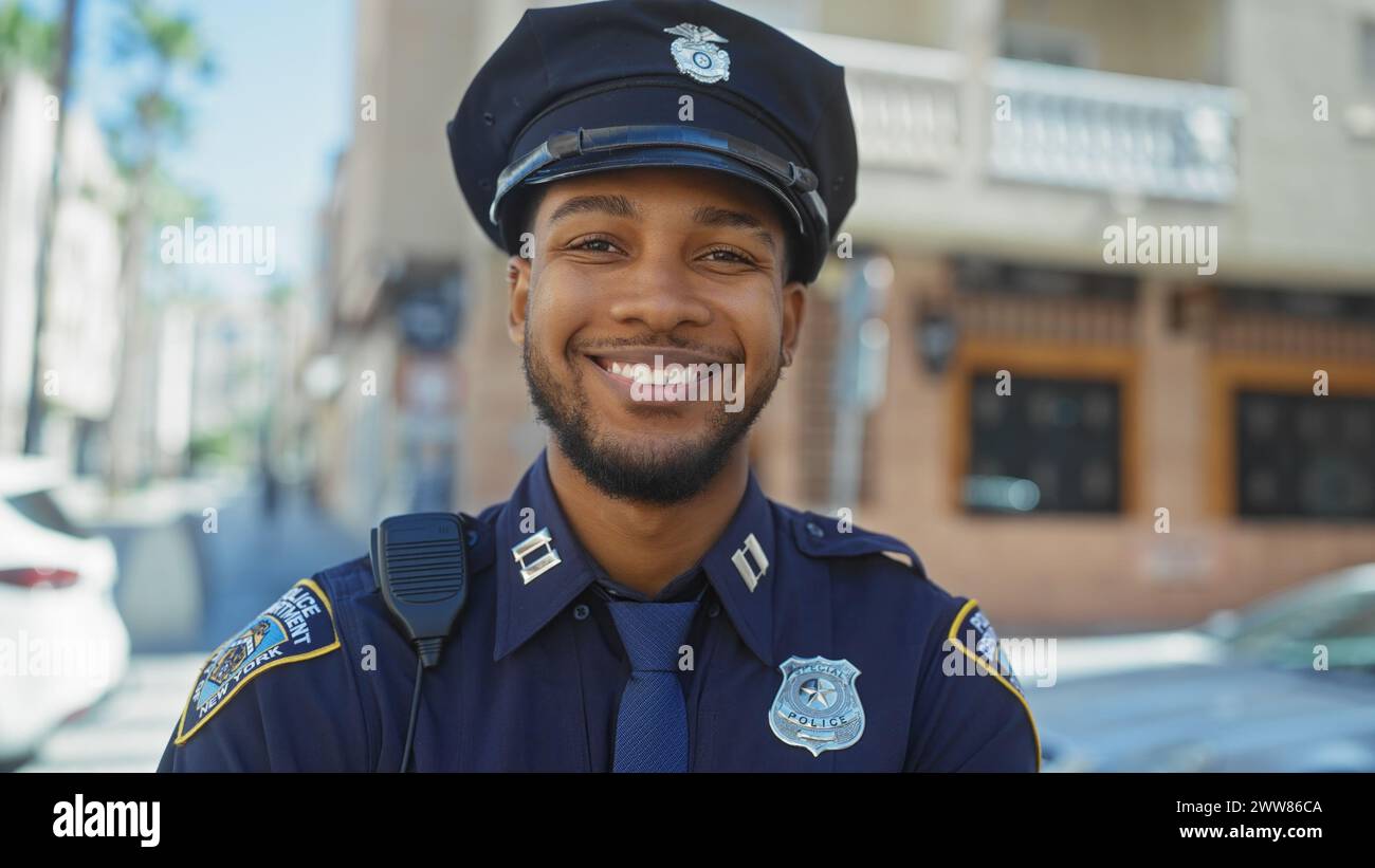 A smiling african american police officer stands confidently outdoors ...