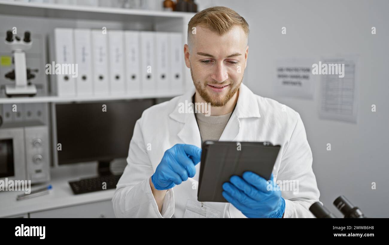 A young caucasian man in a white lab coat and blue gloves examines a ...