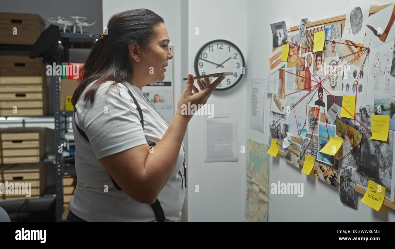 Hispanic woman examines evidence board in police station setting ...